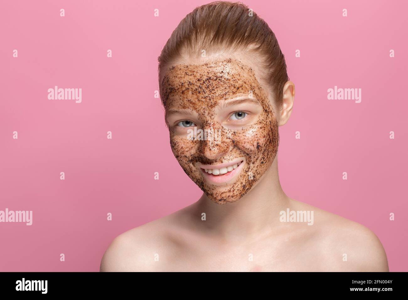 Facial skin scrub Coffee grounds mask on the face of a beautiful young ...