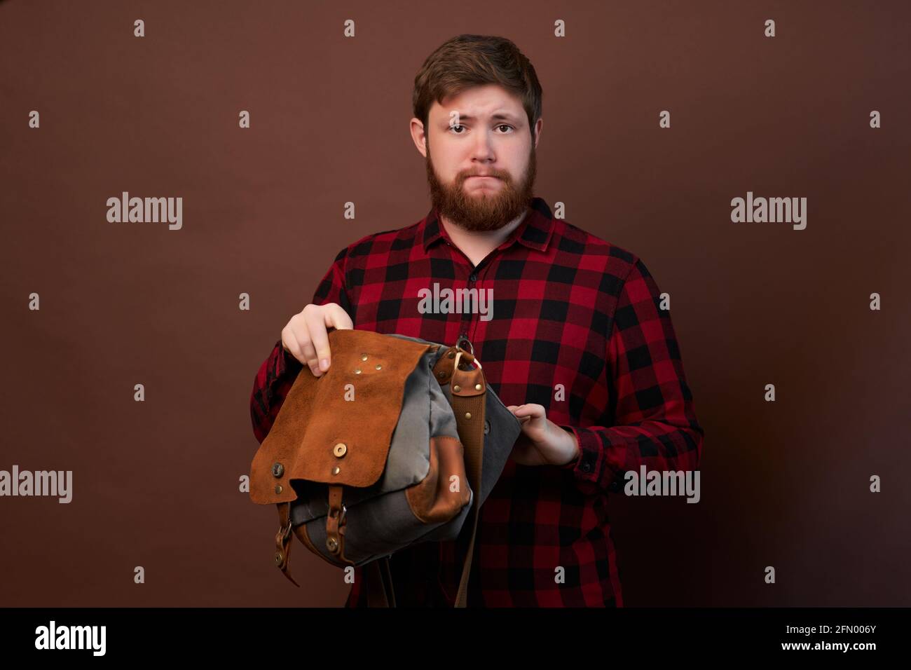 man with emotions on his face with a beard on a brown background, logo ...