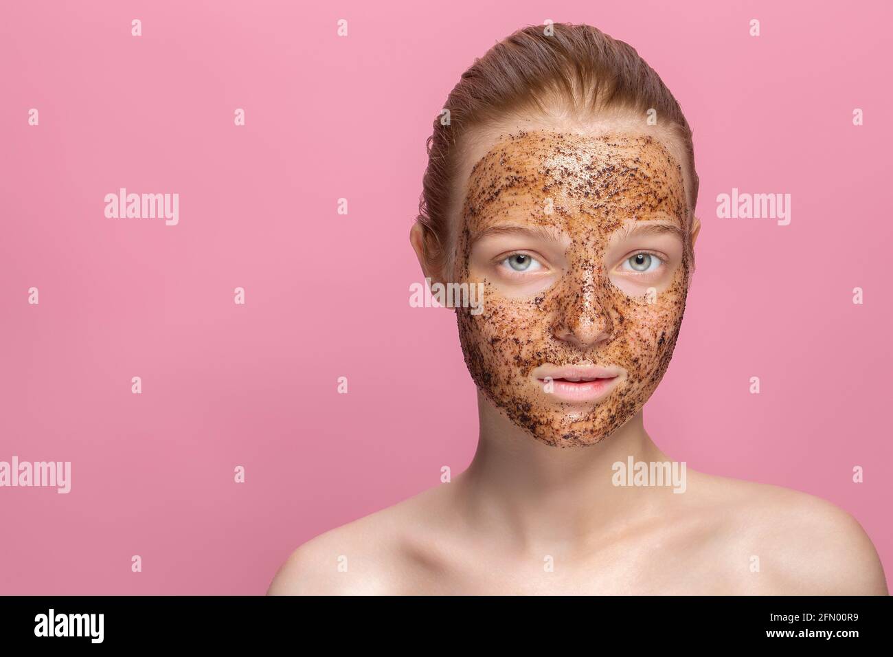 Facial skin scrub Coffee grounds mask on the face of a beautiful young ...