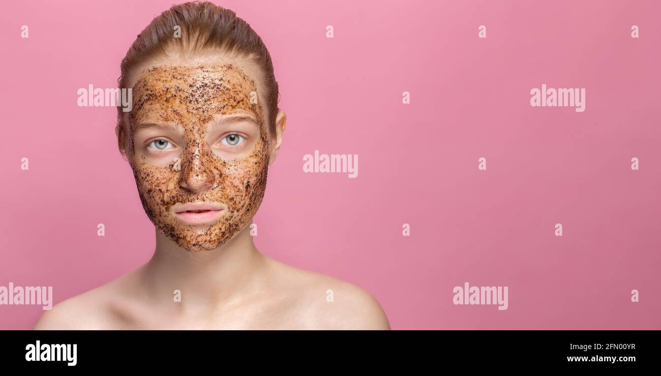 Facial skin scrub Coffee grounds mask on the face of a beautiful young ...