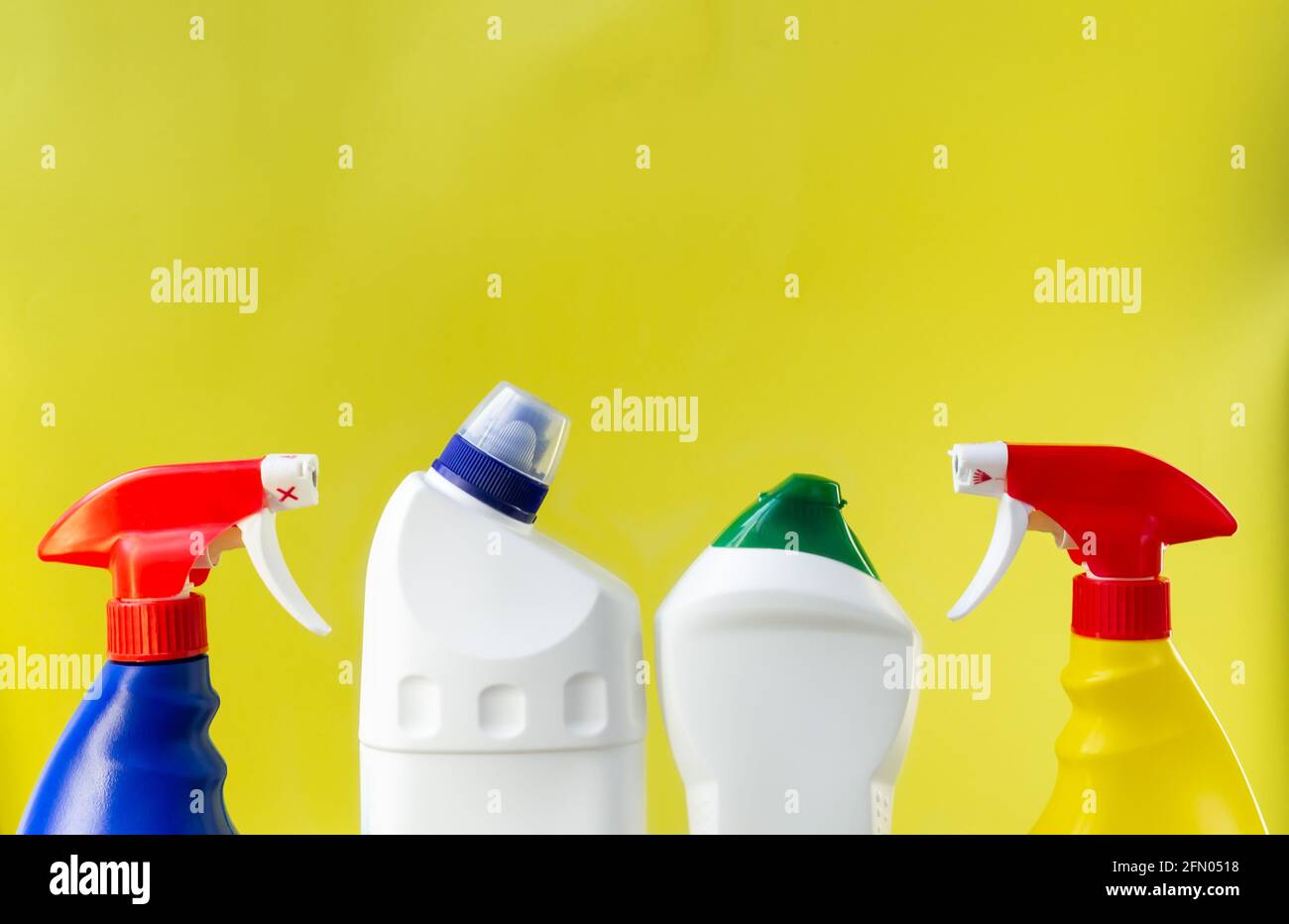 Multi-colored plastic bottles in a row with cleaning products on a ...