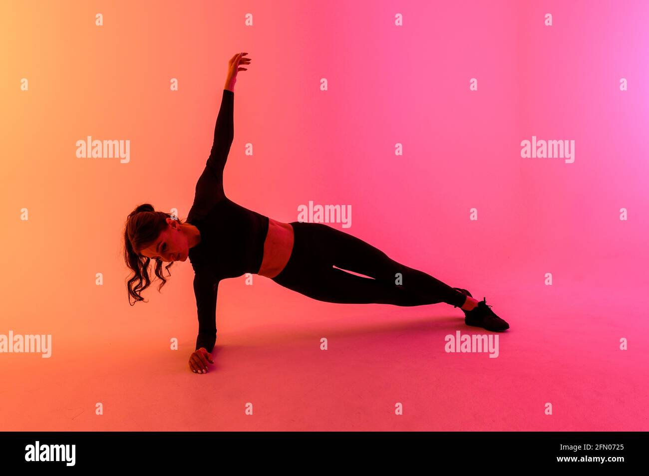 Sports girl on a bright color background does exercises Stock Photo - Alamy