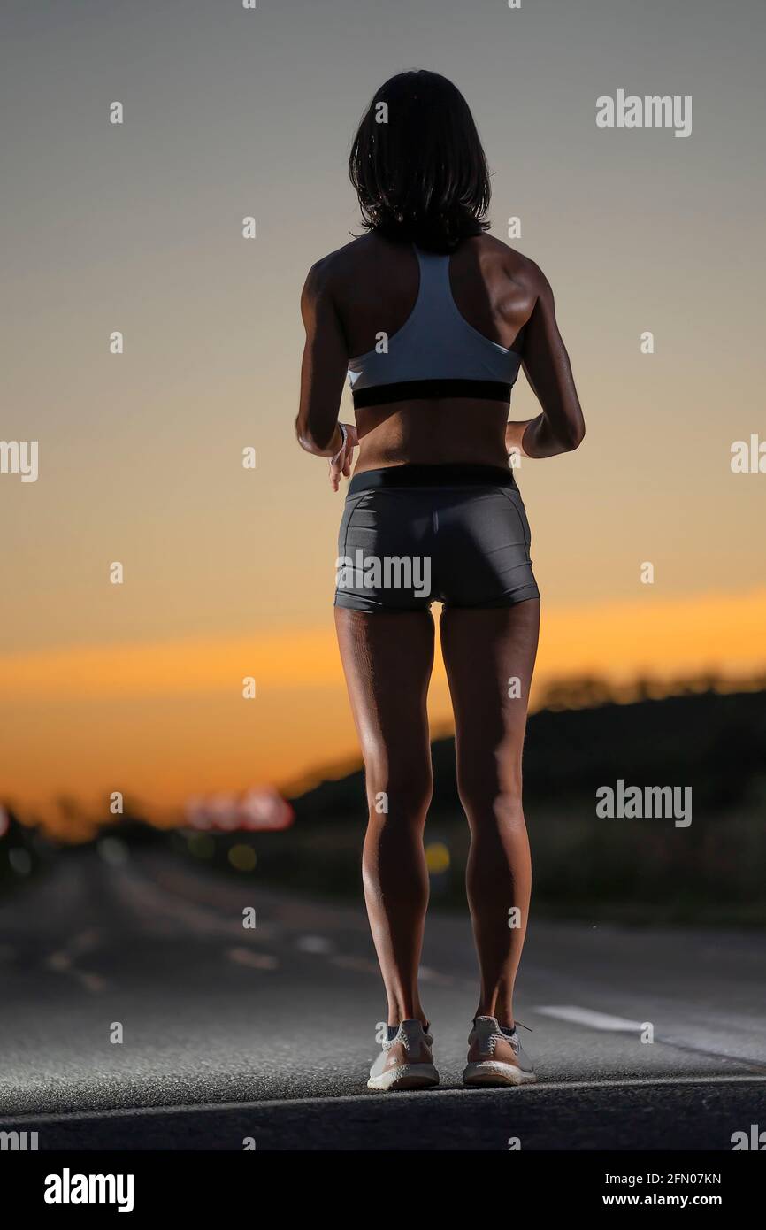 Runner girl looking her way and the sunset Stock Photo - Alamy