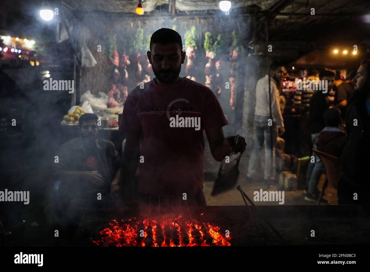 Idlib, Syria. 13th May, 2021. A vendor sells food in a street market in ...