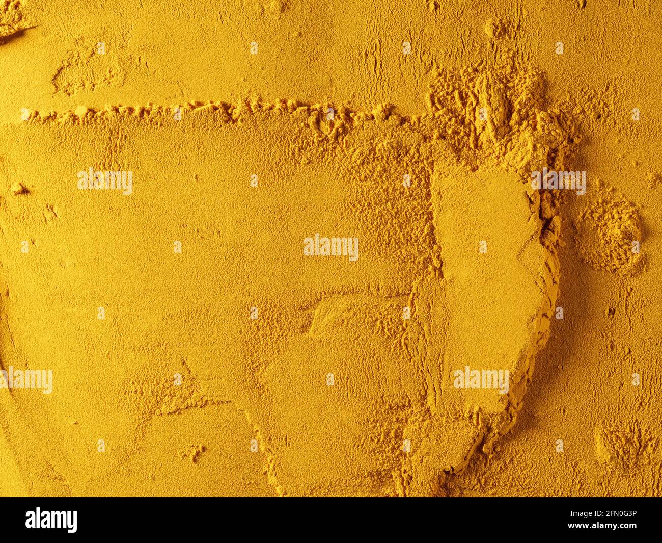 Yellow powder of grated turmeric with texture, food background. View ...