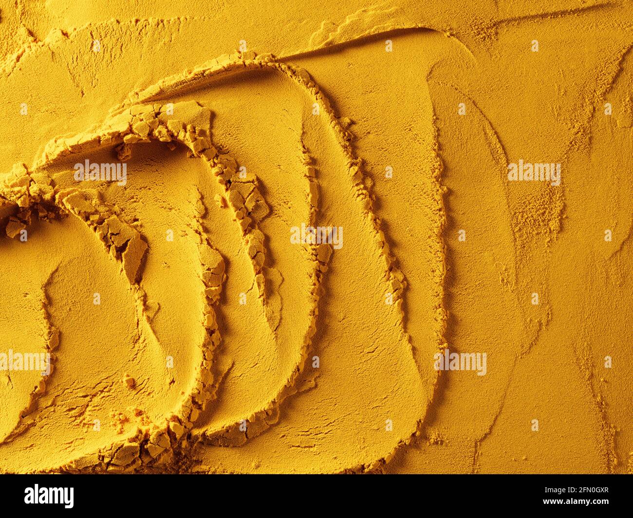 Yellow powder of grated turmeric with texture, food background. View ...