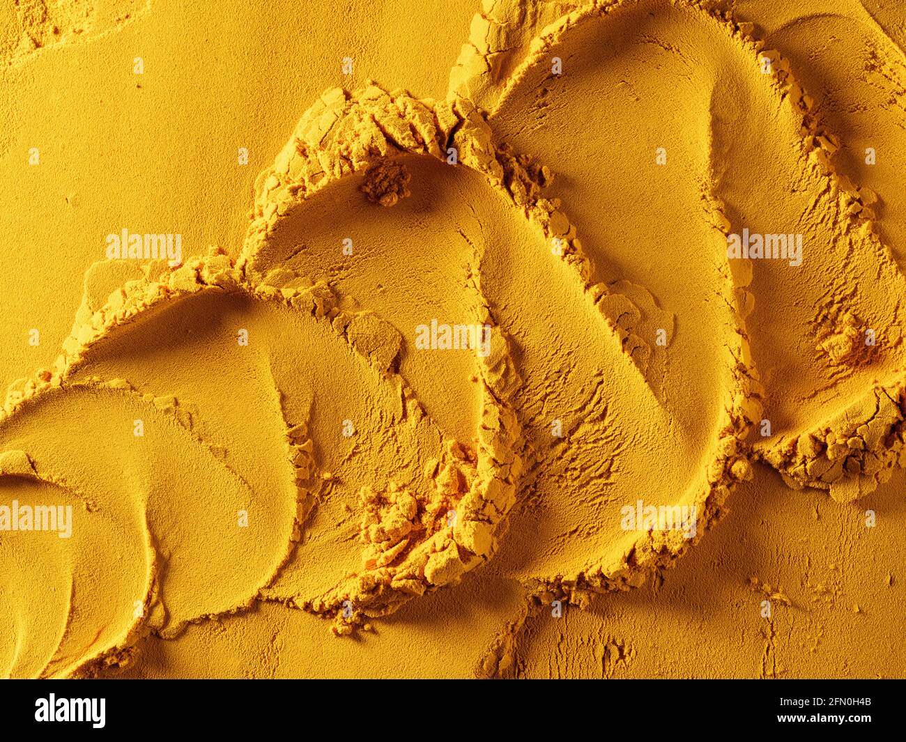 Yellow powder of grated turmeric with texture, food background. View ...