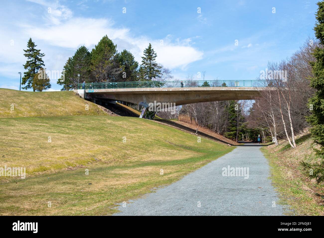 An underneath view of a cement overpass bridge with metal rails. The ...