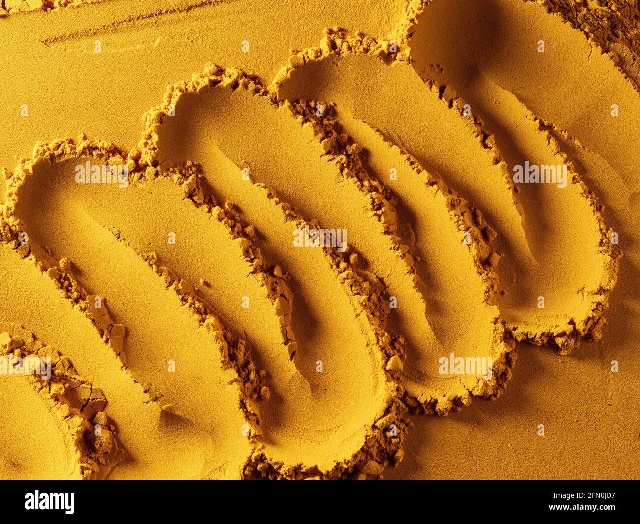 Yellow powder of grated turmeric with texture, food background. View ...