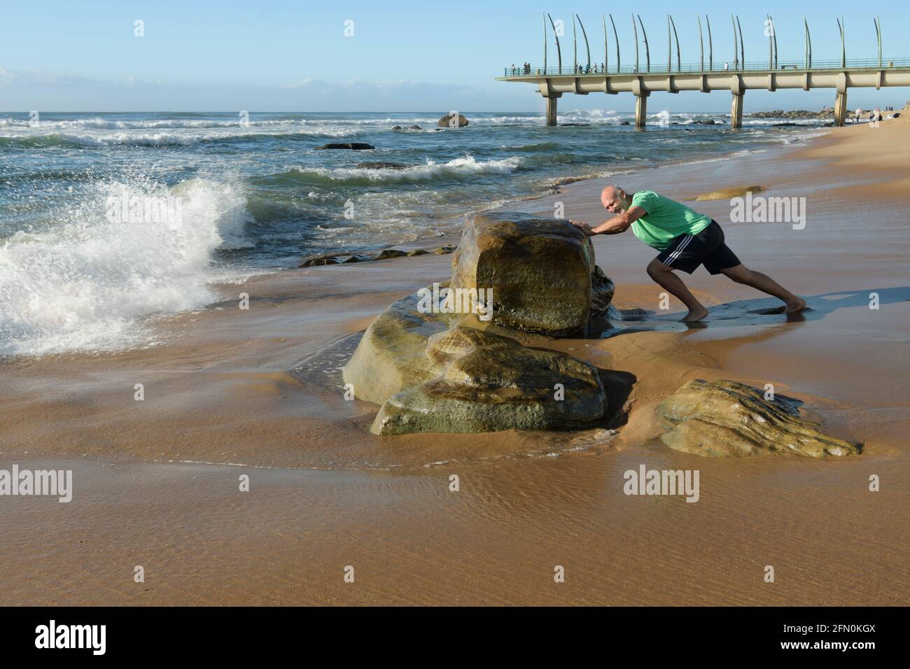 Funny older man pushing rock, fit senior male, comical posing, metaphor ...