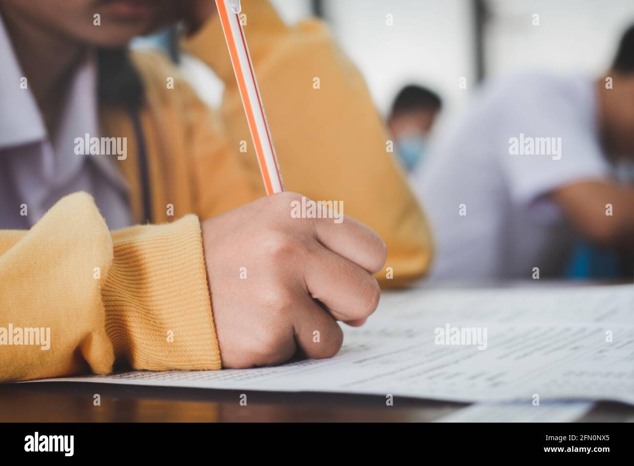 Students writing and reading exam answer sheets exercises in classroom ...