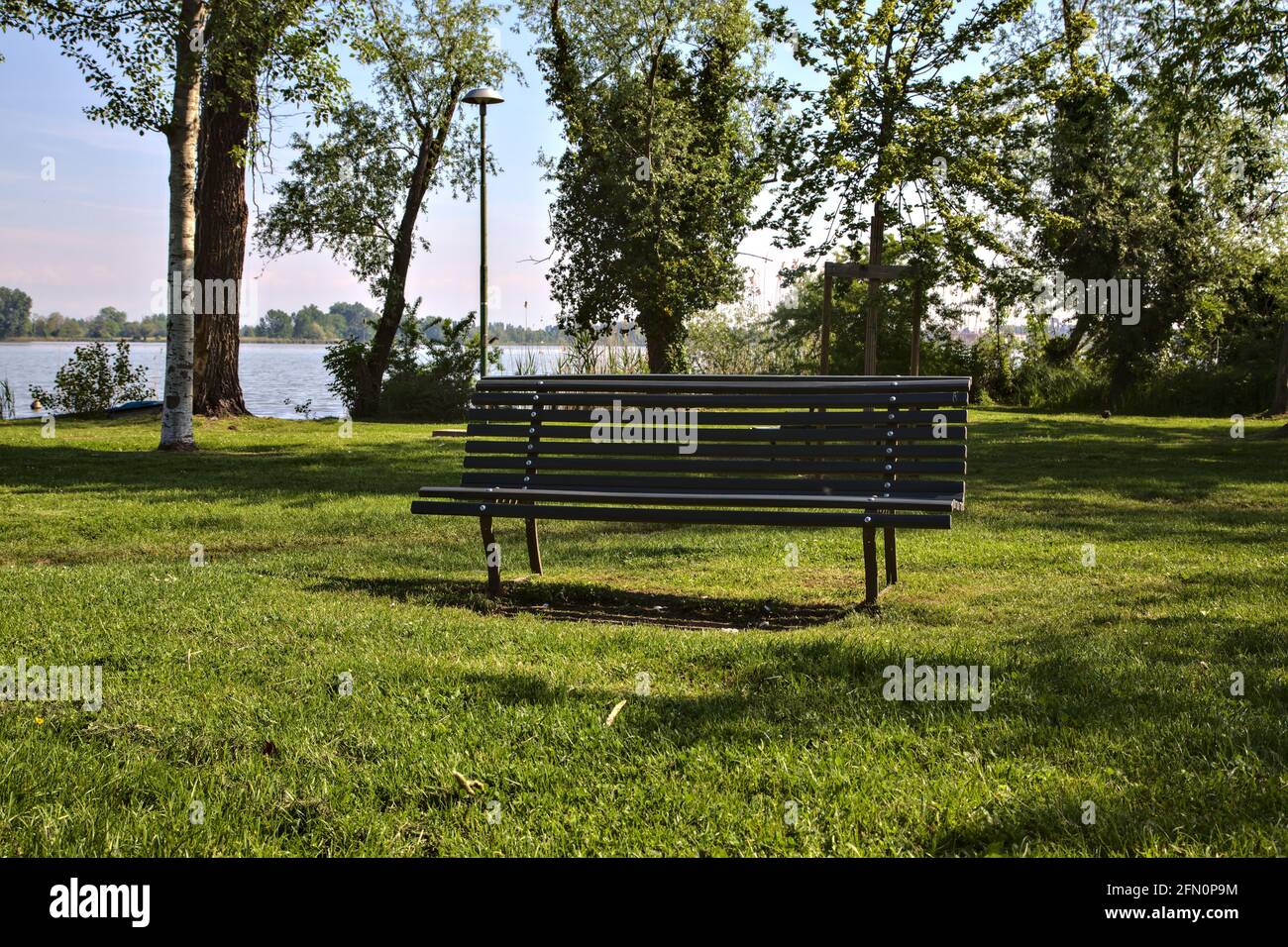 Bench next to the shore of a lake in a park in an italian town Stock ...