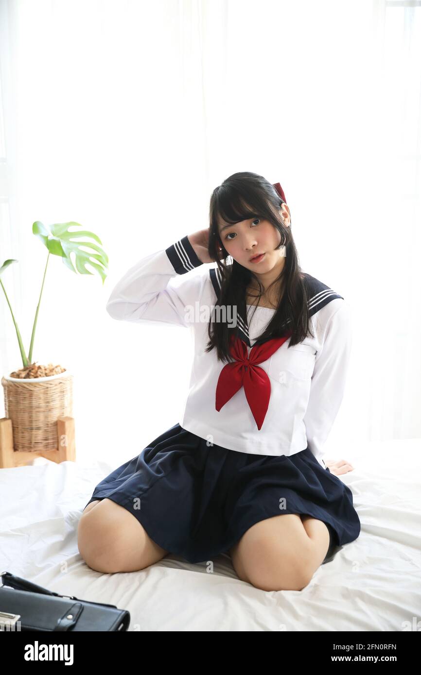 japanese school girl sitting on bedroom in white tone Stock Photo - Alamy