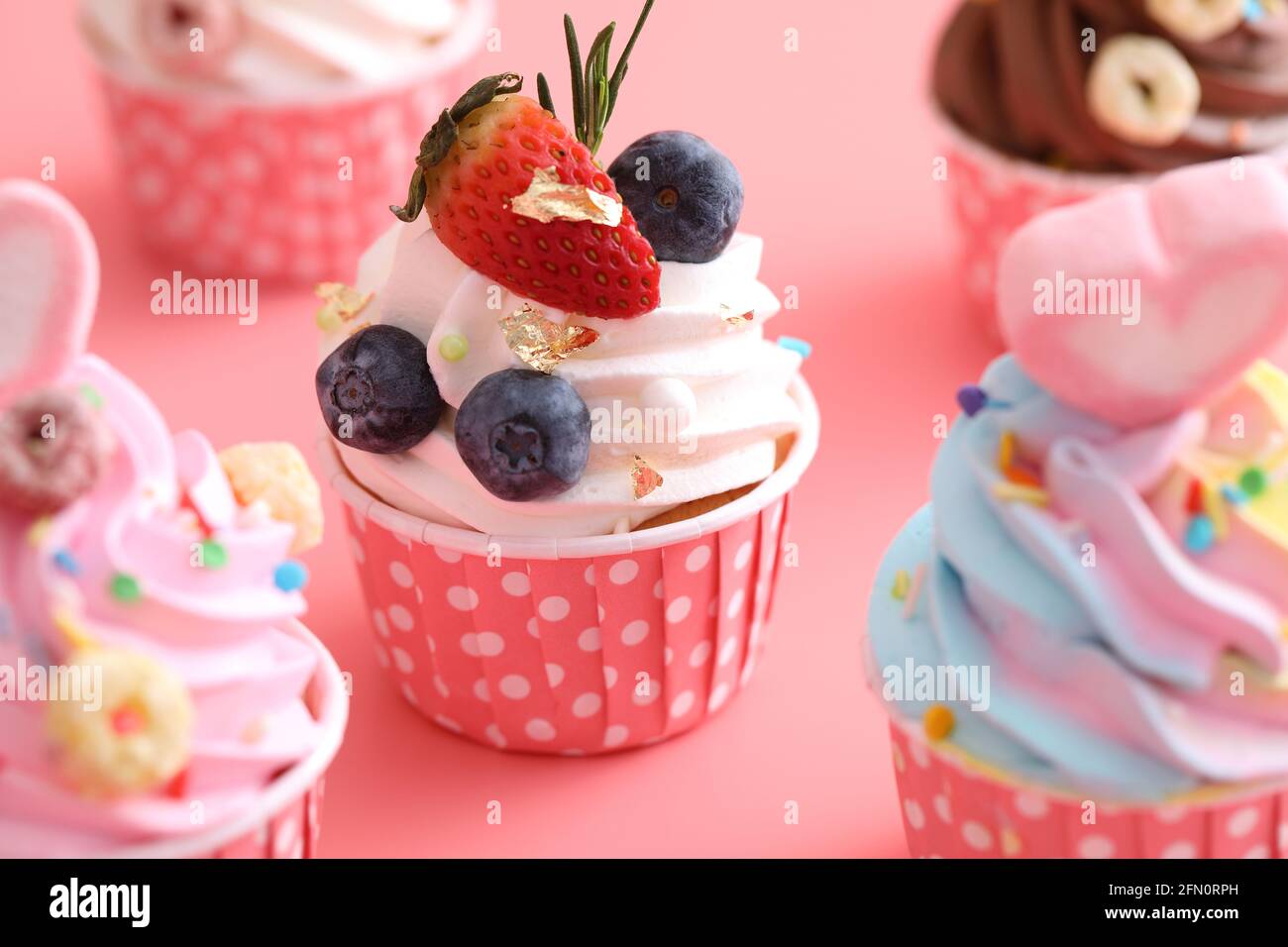 Colorful cupcakes isolated in pink background Stock Photo - Alamy