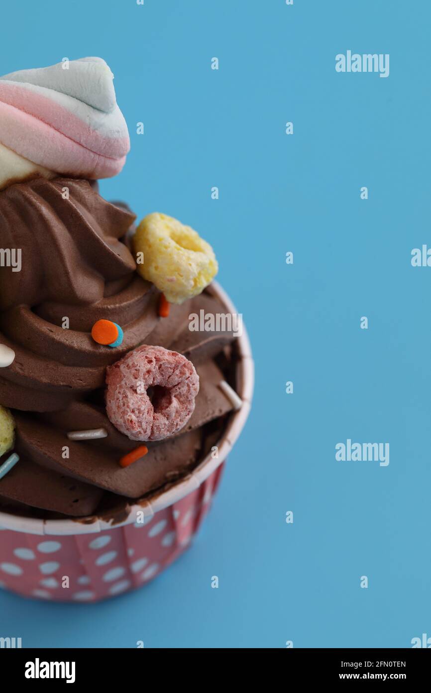 Chocolate cupcake isolated in blue background Stock Photo - Alamy