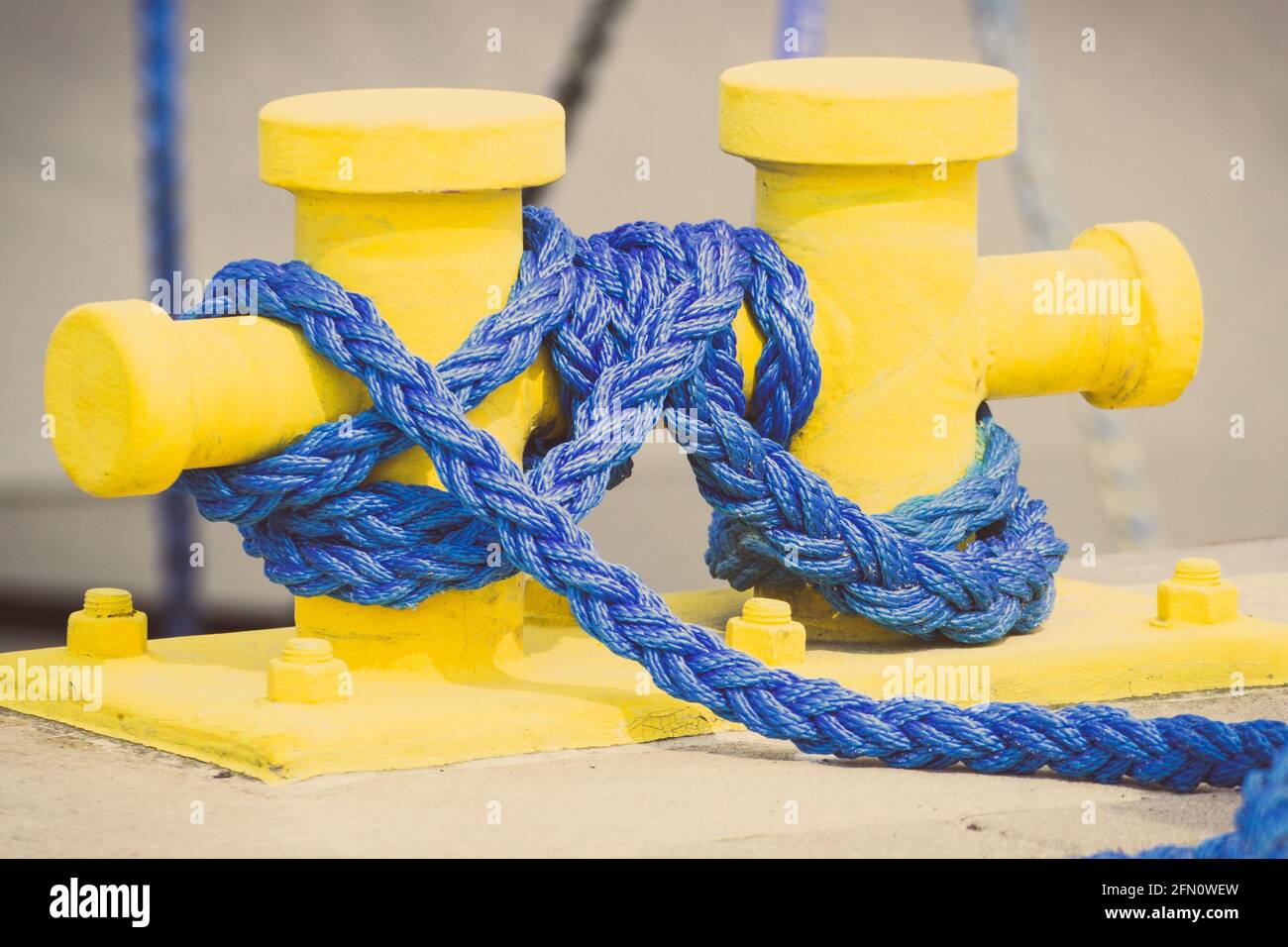 Rope and yellow mooring bollard in seaport hi-res stock photography and ...