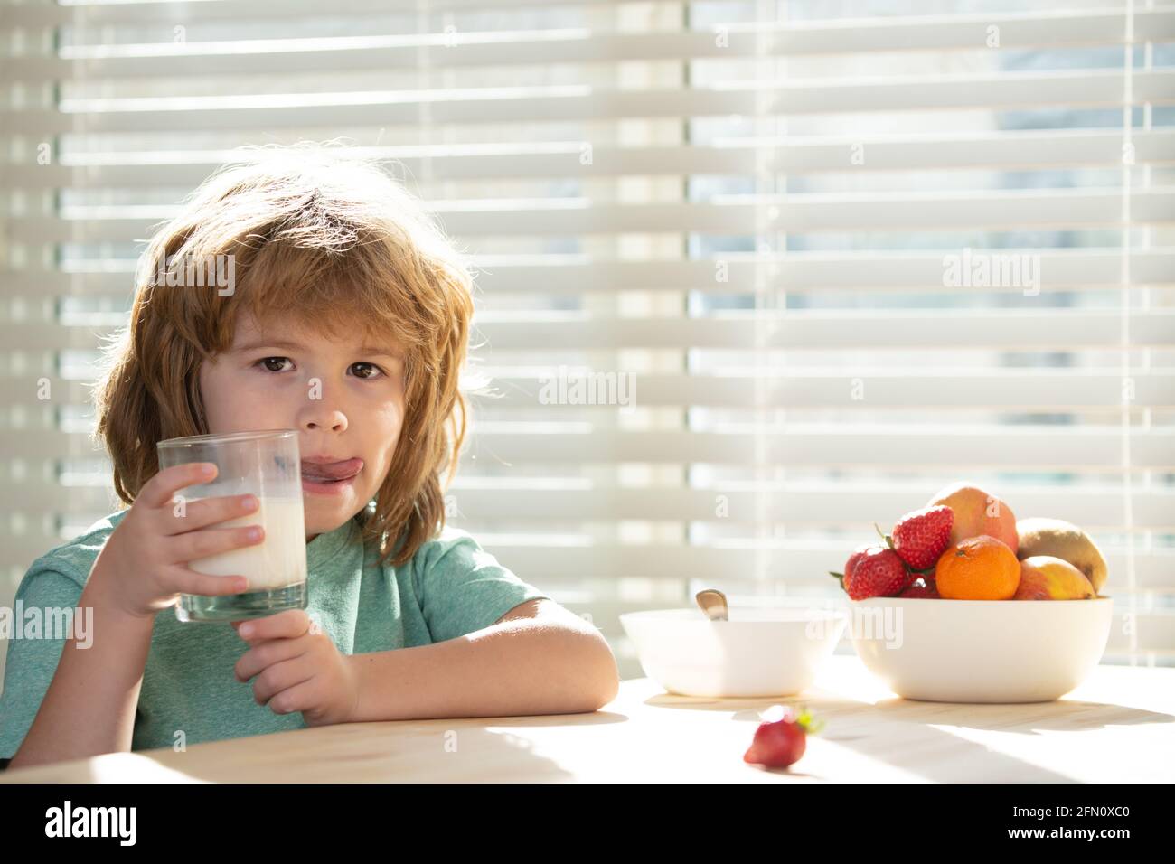 Closeup child drinking tasty milk, pretty preschool kid holding glass ...