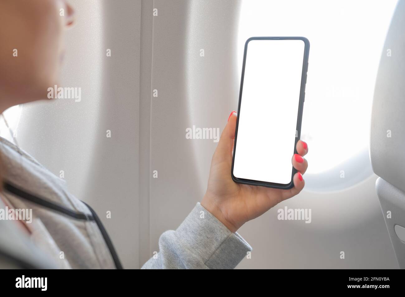 woman hand holding smart cell phone with blank white screen on board of ...