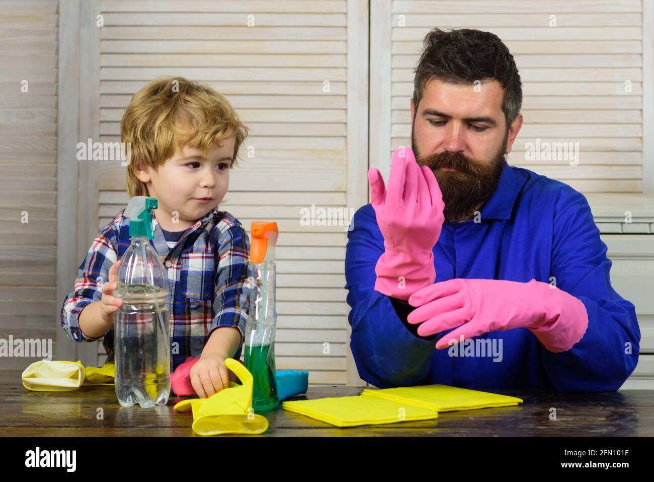 Father and son cleaning. Dad teaching kid little boy use disinfectant ...