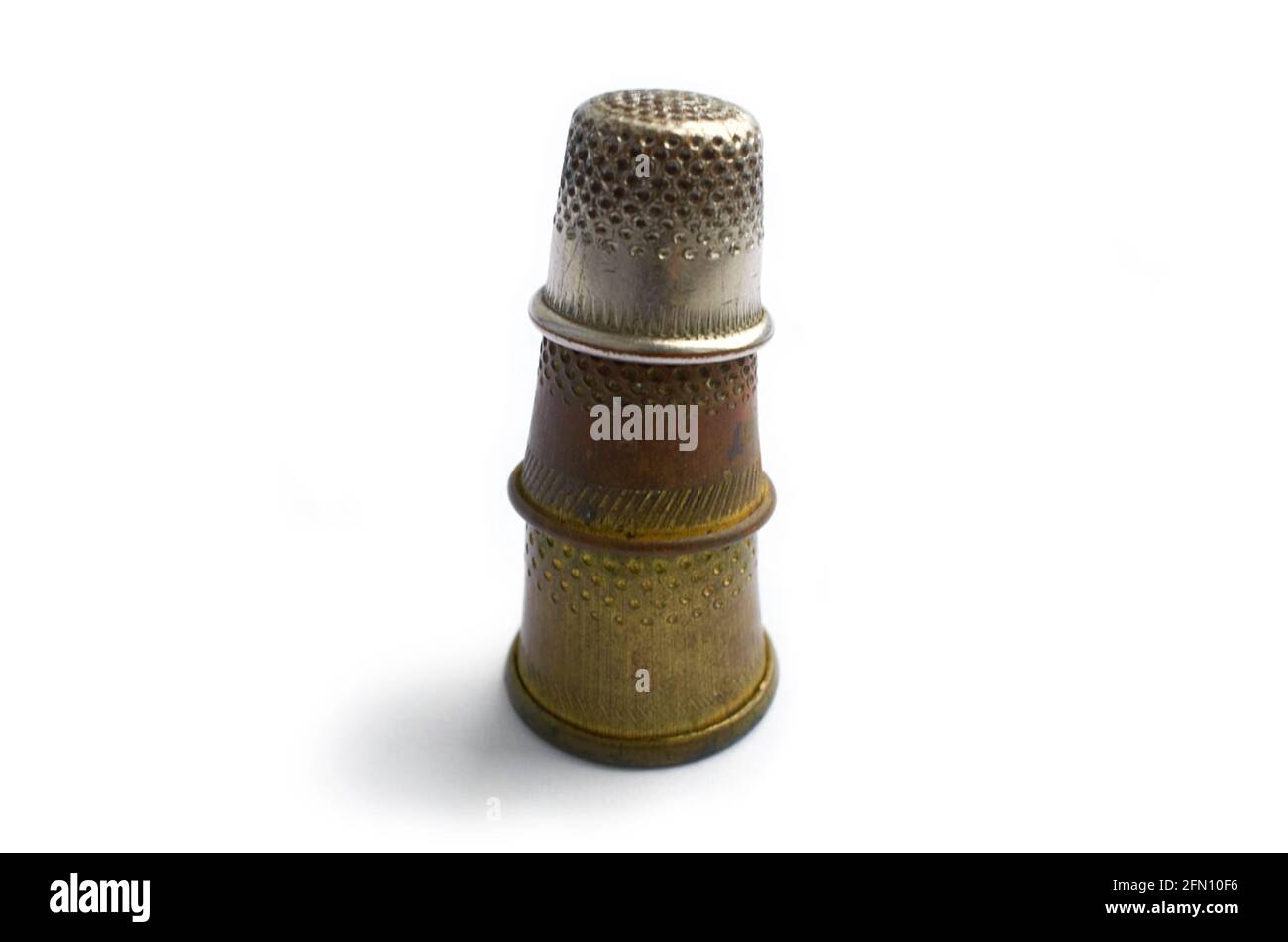 Three vintage thimbles stand in a column on top of each other Stock ...