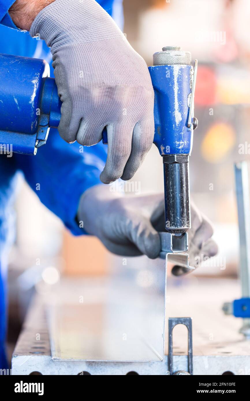 Craftsman rivet metal with air compressed pistol in workshop Stock ...