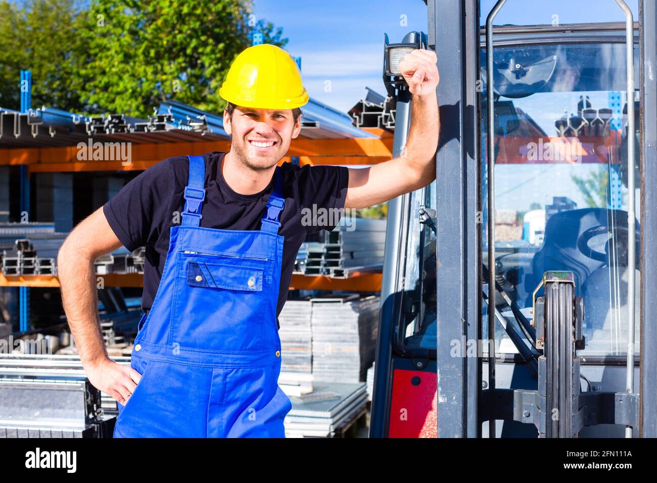 builder or driver with pallet transporter or lift fork truck on ...