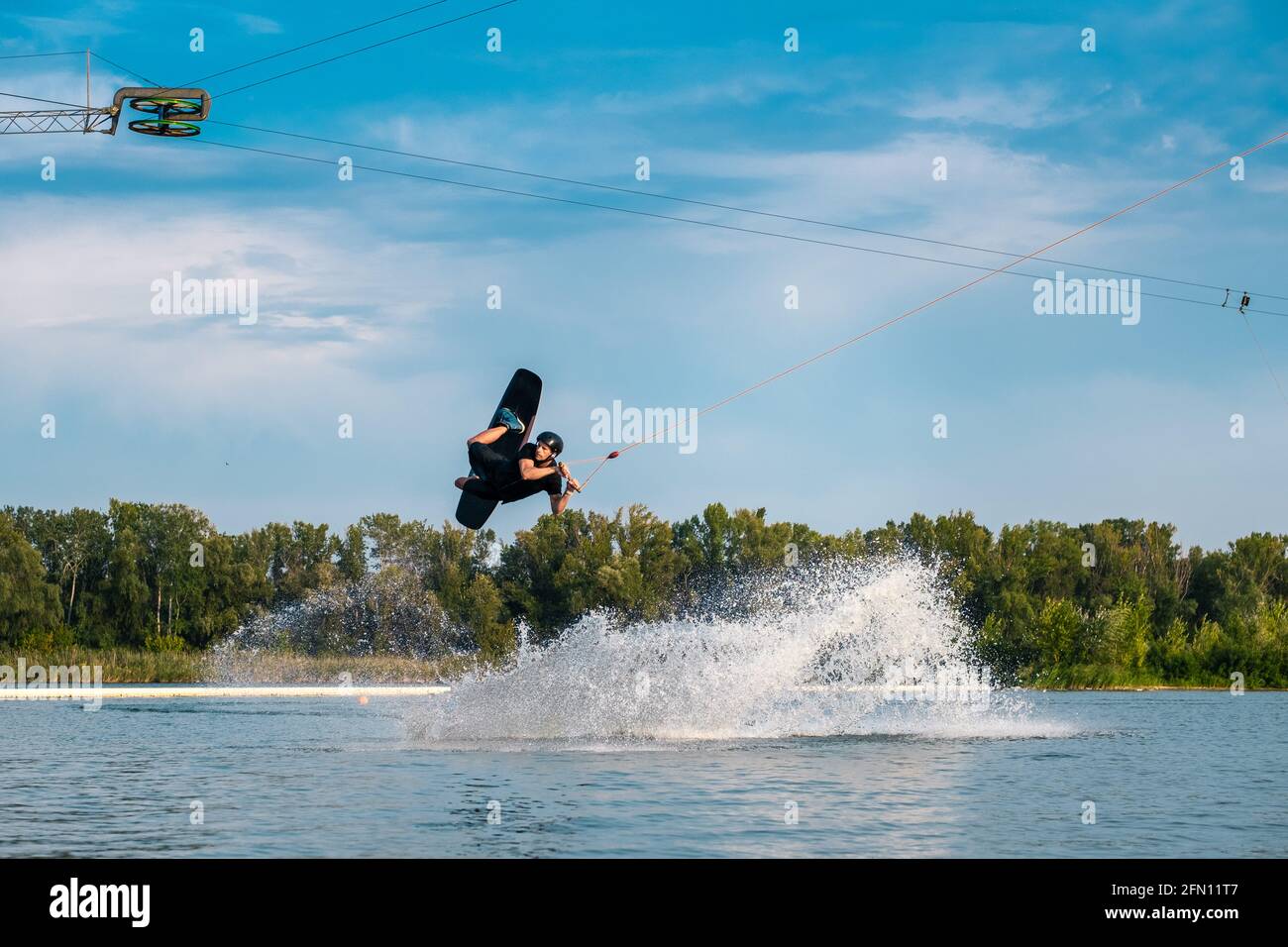 Wakeboard rider towed on cable jumping in open water Stock Photo - Alamy