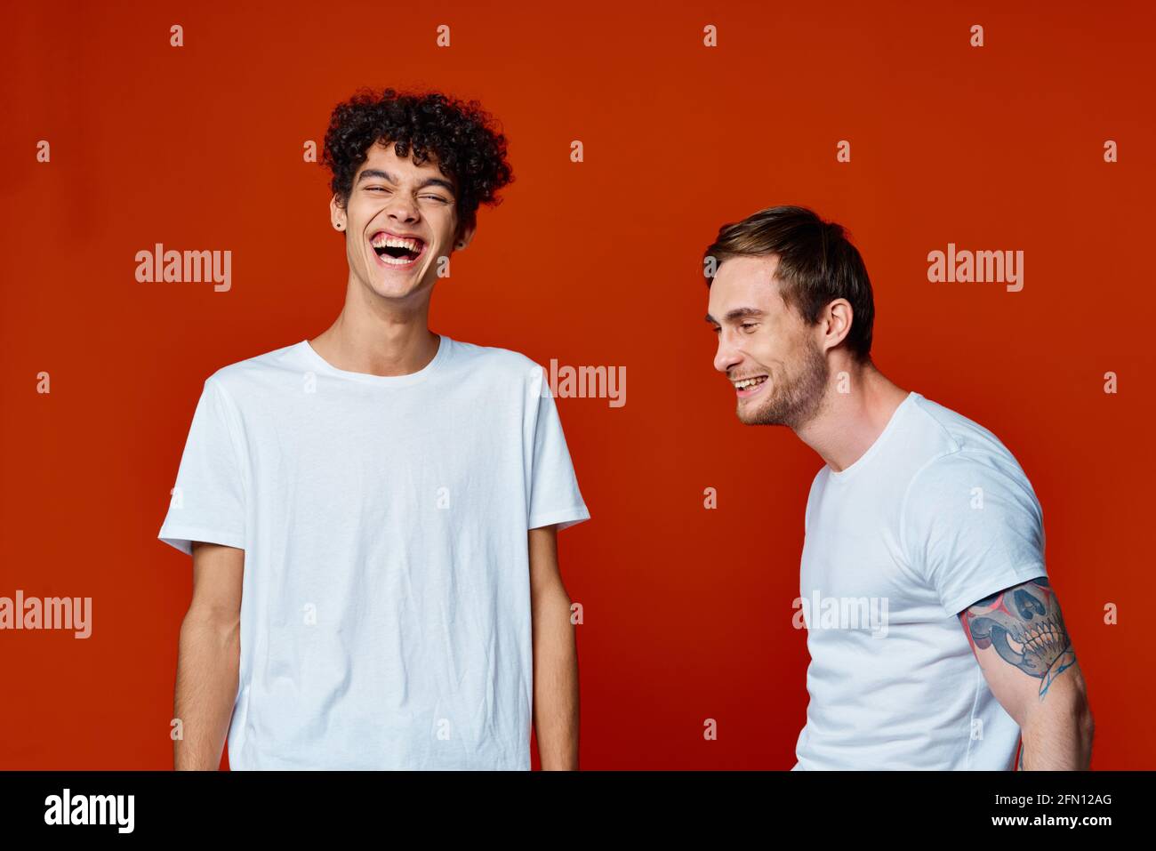 two men in white t-shirts on a red background friendship Stock Photo ...