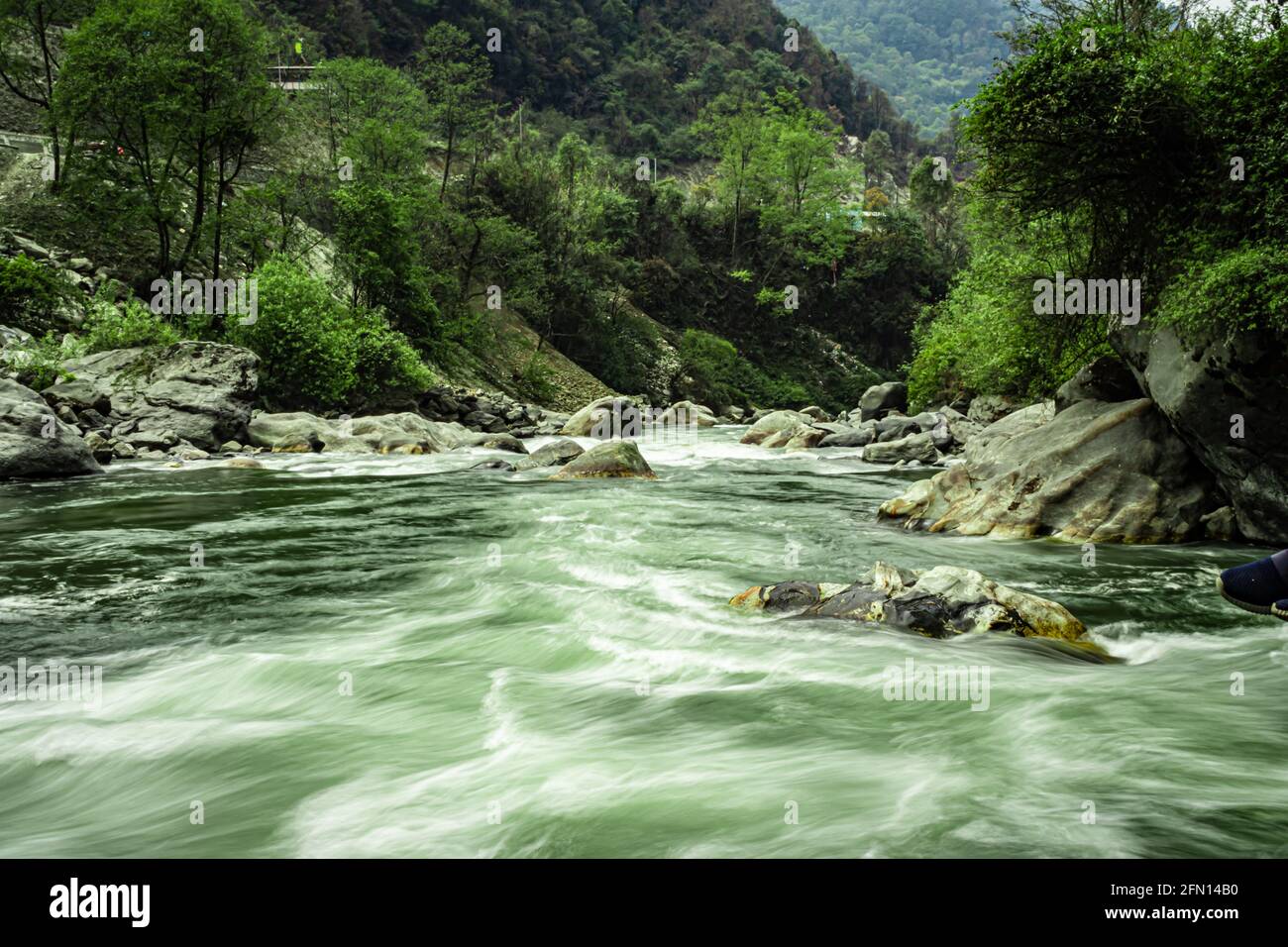 mountain river extreme water flow at forests in day long exposure shot ...