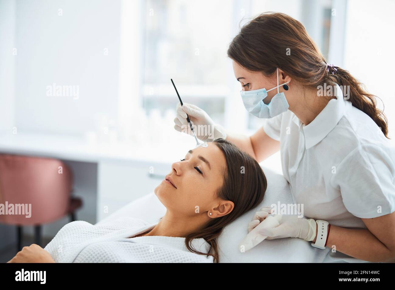 Dermatologist applying a face mask to the patient skin Stock Photo - Alamy