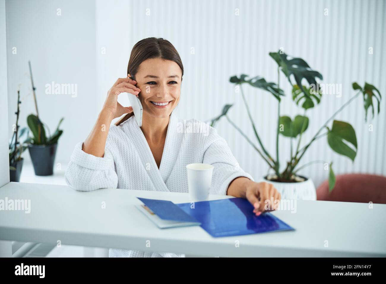 Happy spa client calling on her smartphone Stock Photo - Alamy