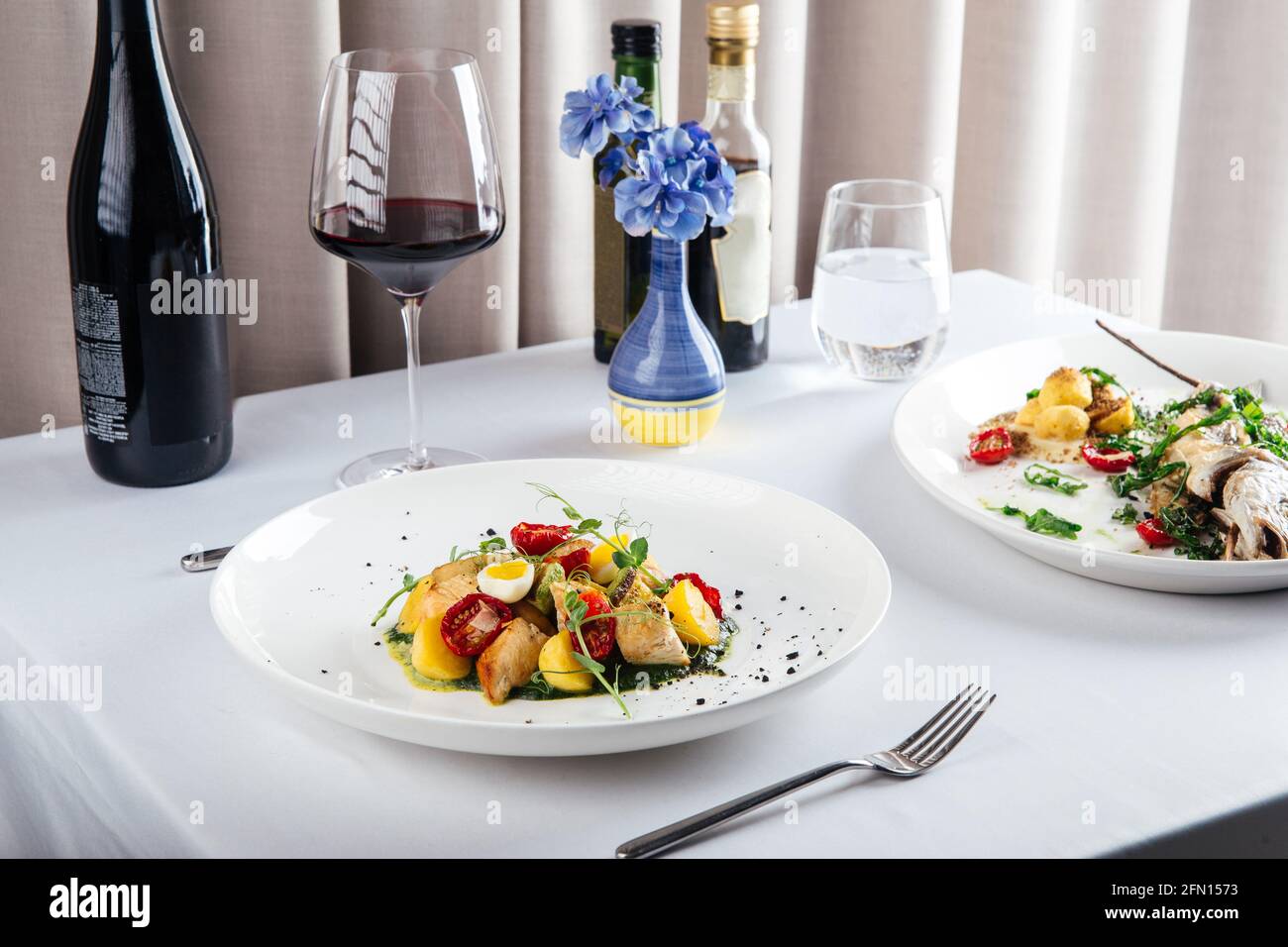 Mediterranean restaurant dishes with red wine Stock Photo - Alamy