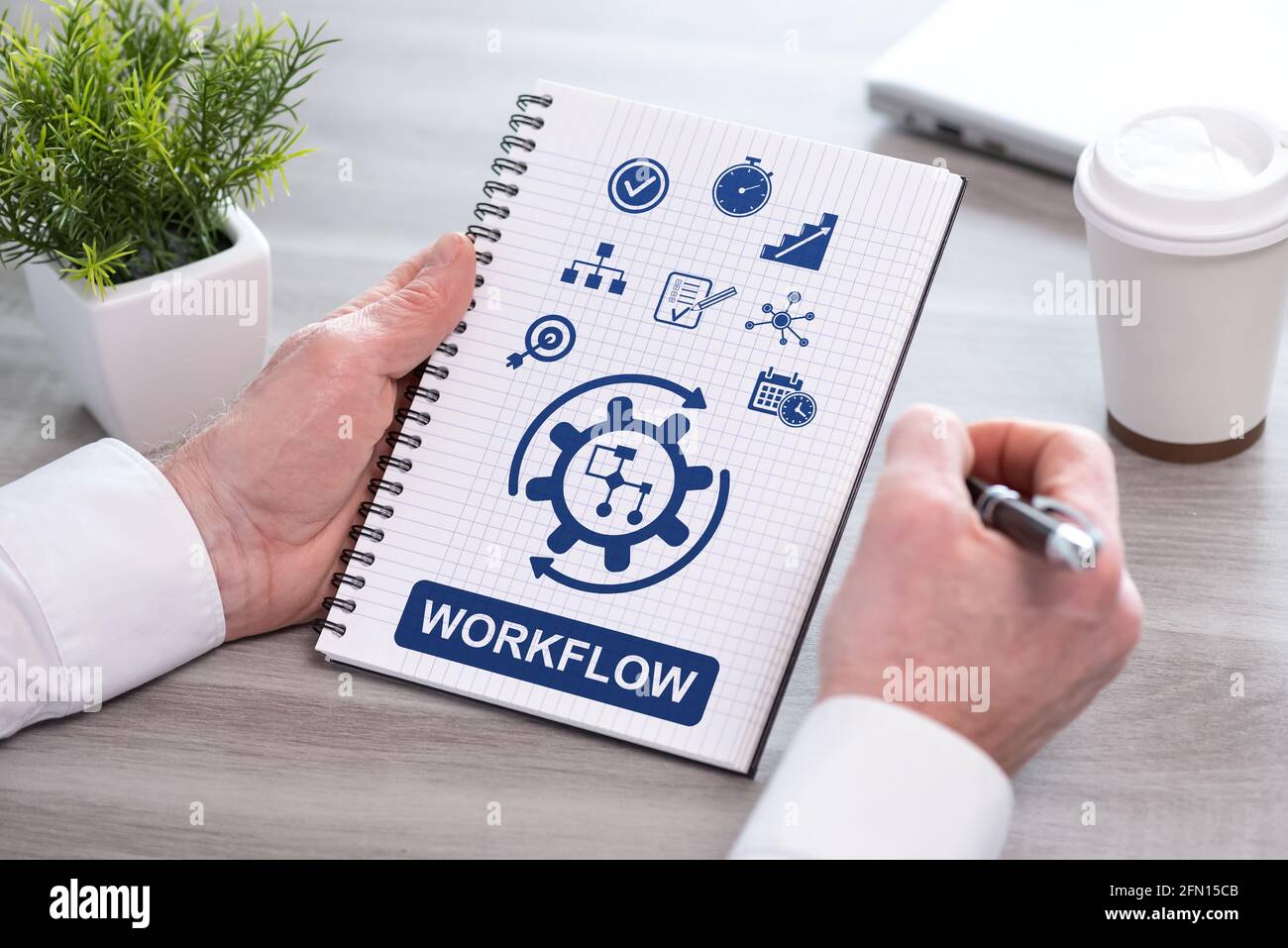 Hand holding a notepad with workflow concept Stock Photo - Alamy