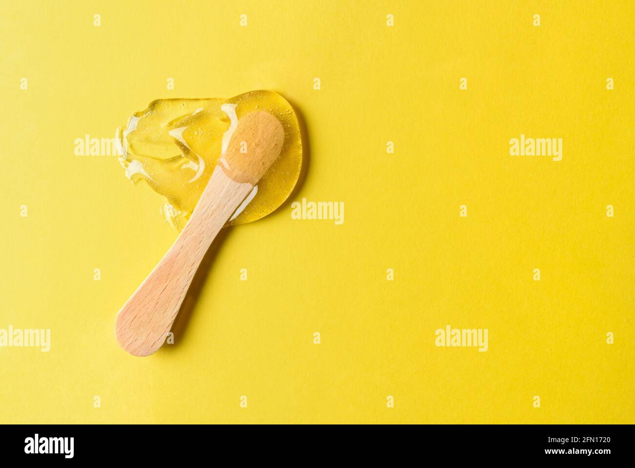 Liquid sugar wax smear with spatula on yellow background Stock Photo ...
