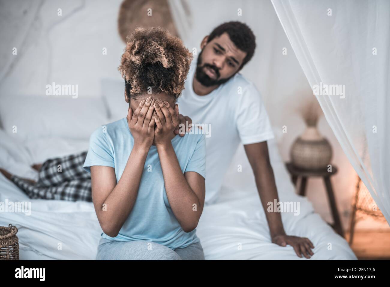 Woman covering her face with hands and man Stock Photo - Alamy