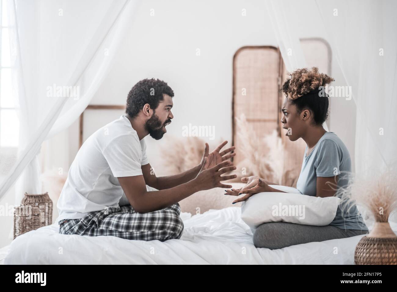 Scandalous man and woman sitting opposite each other Stock Photo - Alamy