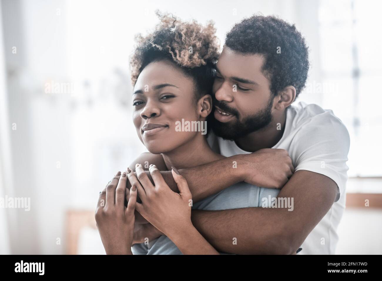 African american hugging happy woman by shoulders Stock Photo - Alamy