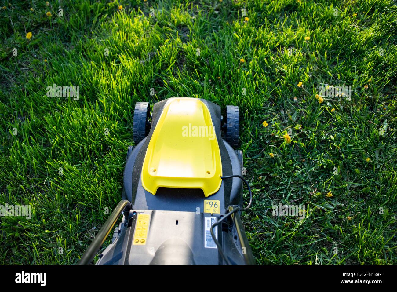 top view of yellow lawn mower in green grass Stock Photo - Alamy