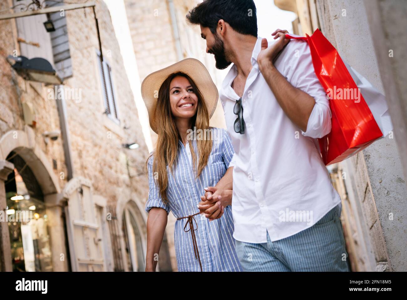Happy couple of tourists walking and shopping in a city street Stock ...
