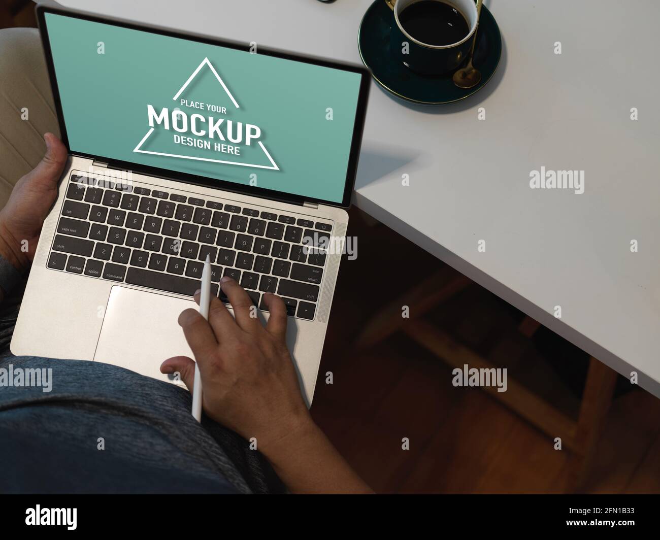 Overhead shot of male office worker working with mock up laptop while ...