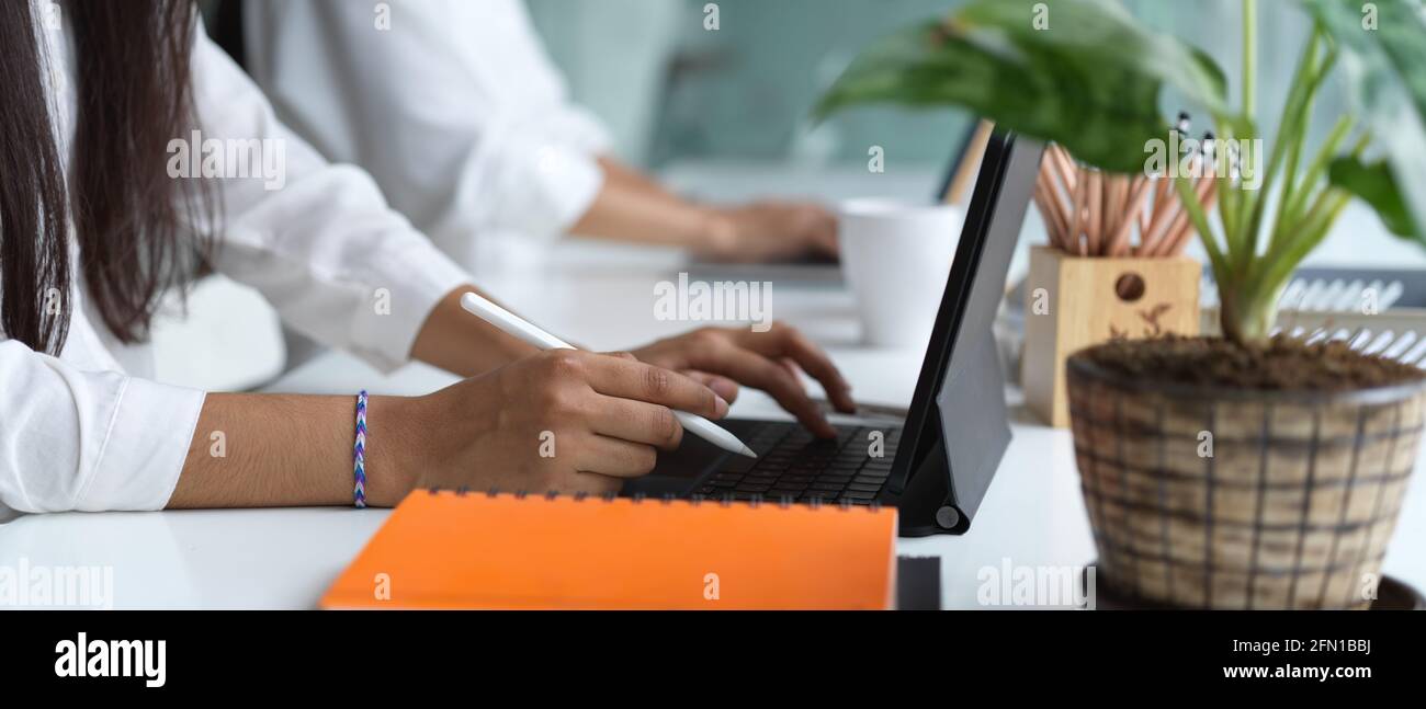 Side view of female university students doing assignment with digital ...