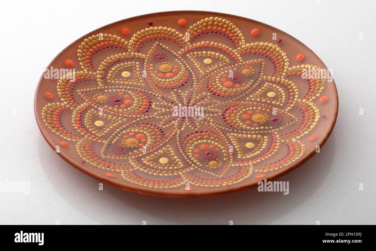 Yellow decorative plate with a mandala pattern Stock Photo - Alamy
