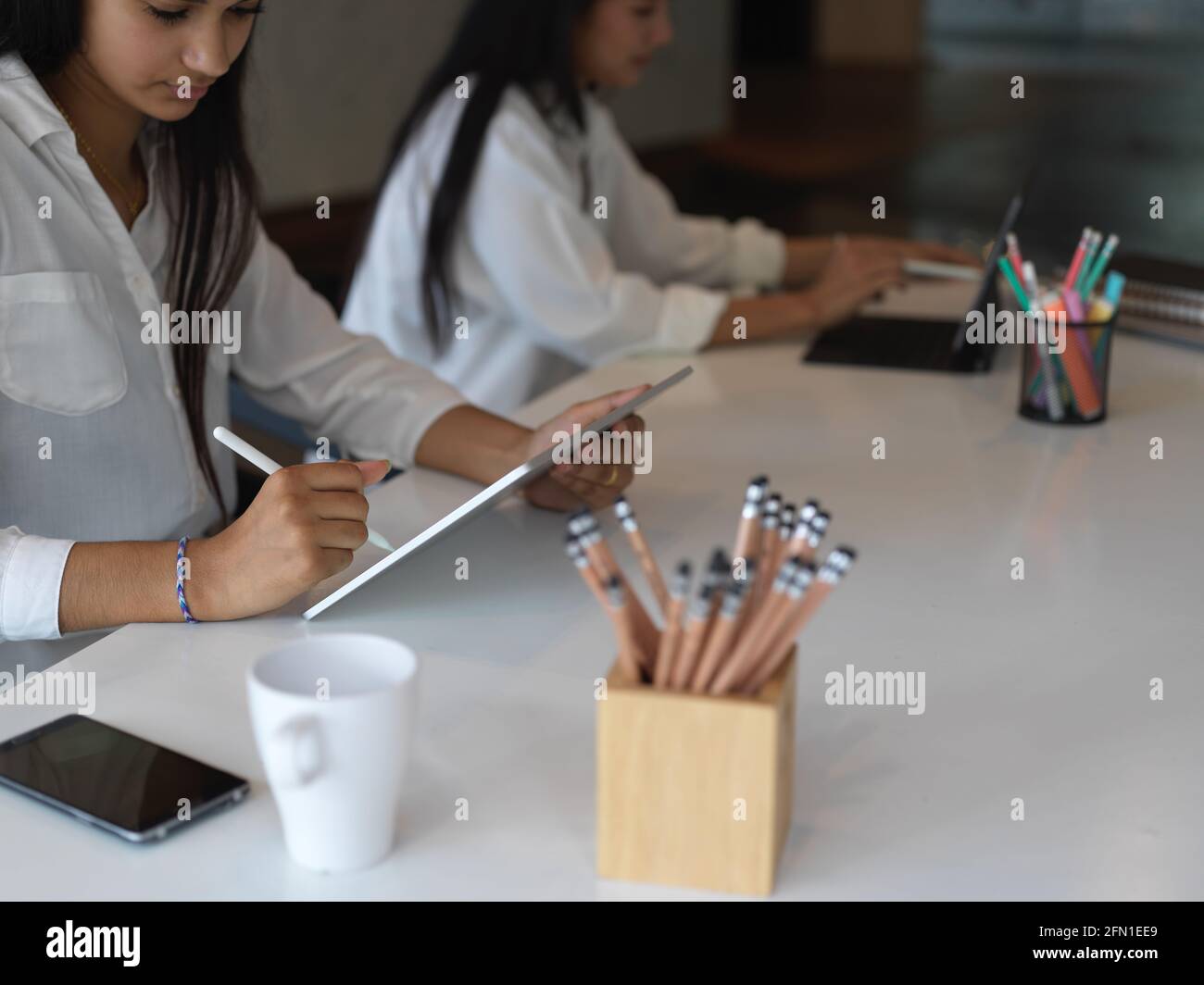 Side view of female university students doing assignment with digital ...