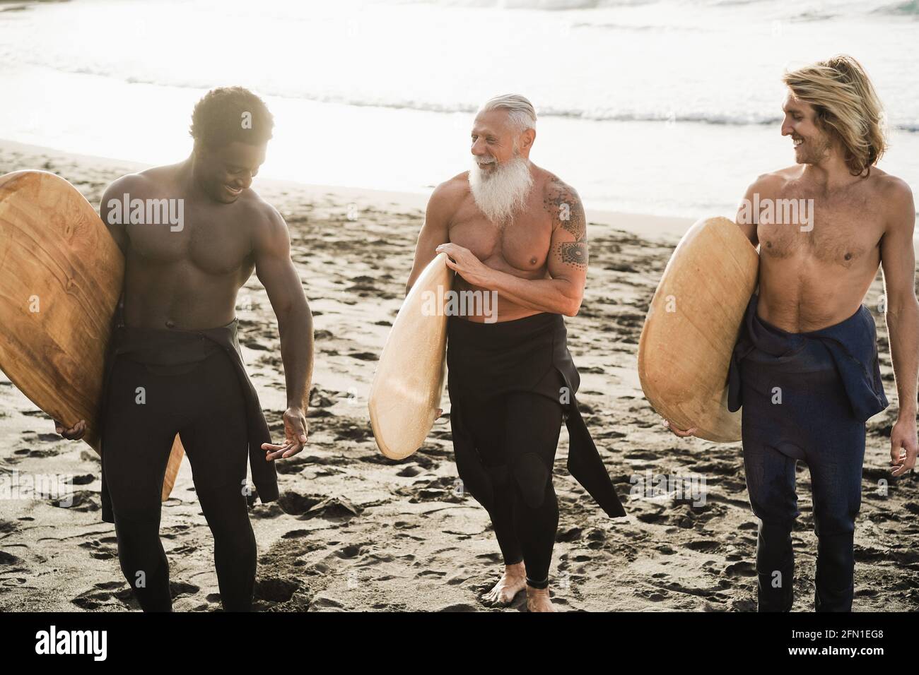 Multi generational surfer men having fun on the beach - Main focus on ...