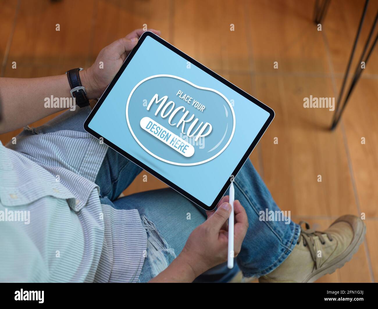 Overhead shot of male worker using mock up tablet on his lap while ...