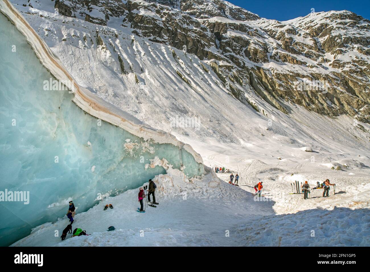 Tourists marvel at the ice cave at the end of the glacier in Zinal ...