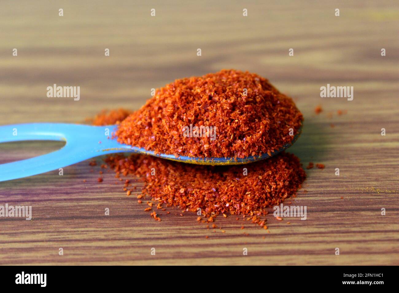 Red chilli powder spice background on wood, selective focus with blur ...