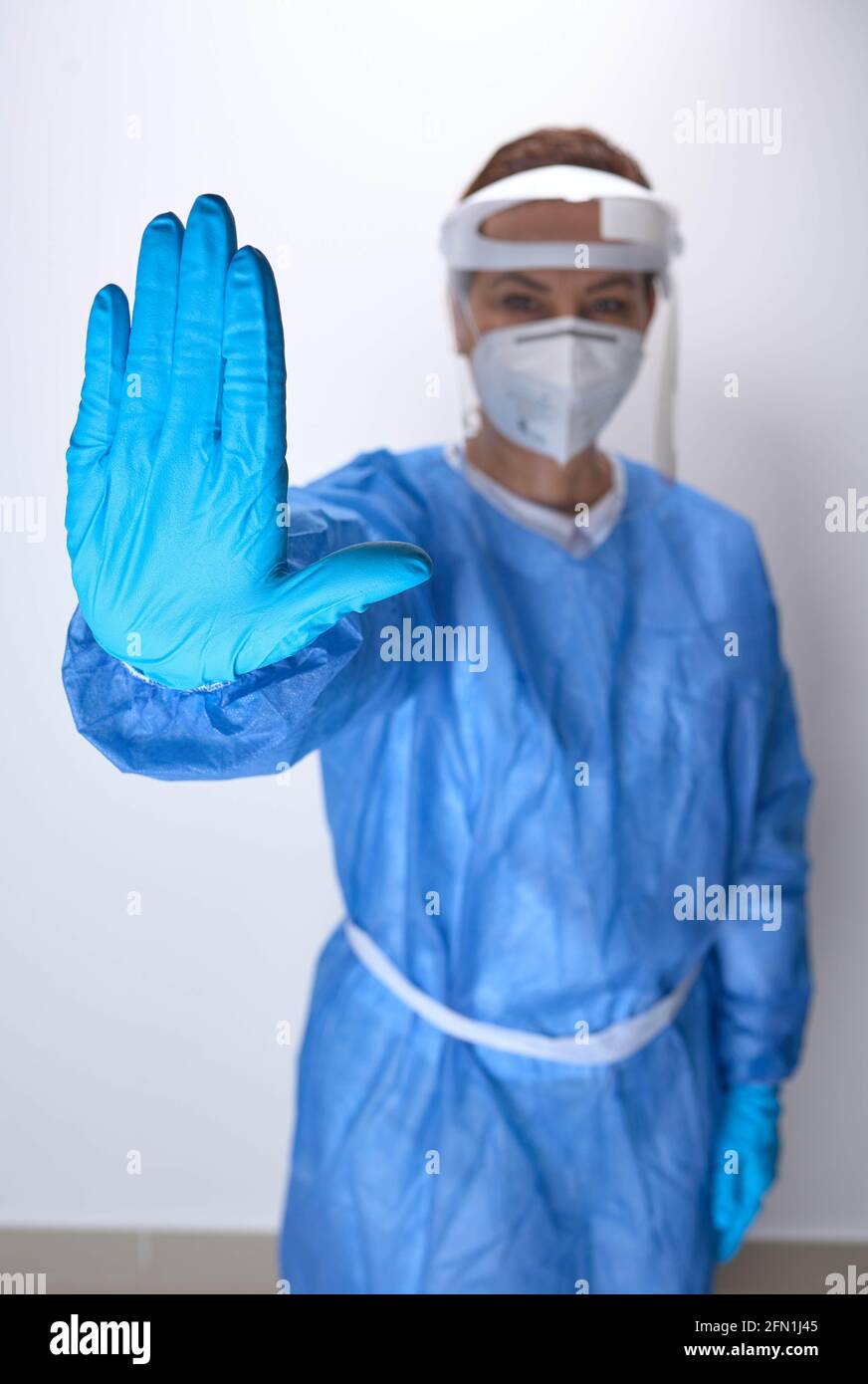 Vertical shot of a Colombian doctor gesturing the stop sign with hand ...