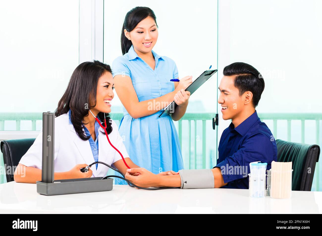 Asian female doctor check-up blood pressure on patient while nurse ...