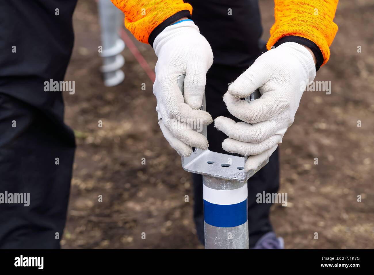 the builder twists the foundation made of screw piles. Lightweight and ...